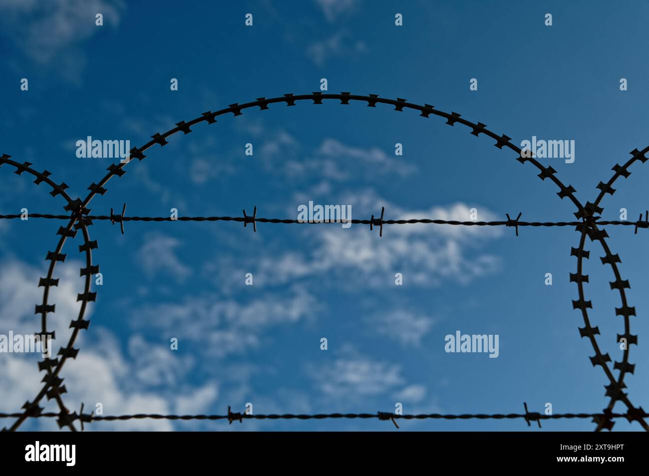 Sharp razor wire and barbed wire are strung to prevent entry Stock ...