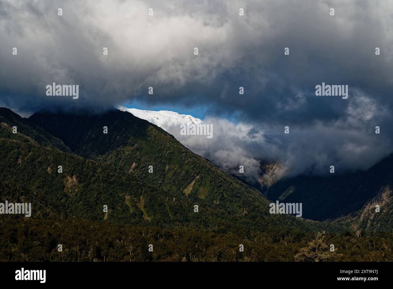 Low clouds throw their shadows on foot hills while snow capped ...