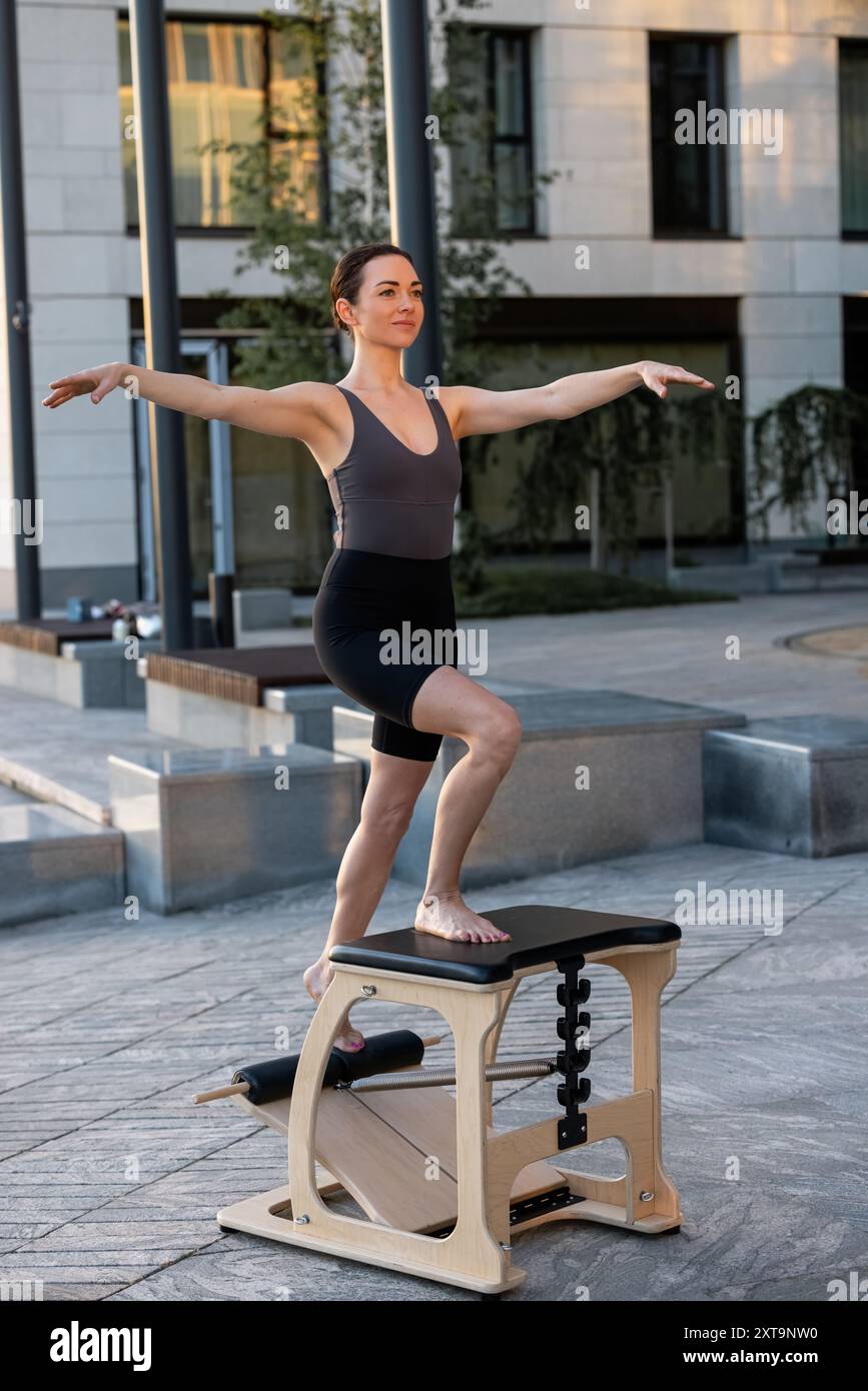 Pilates reformer chair woman fitness yoga gym exercise Stock Photo - Alamy