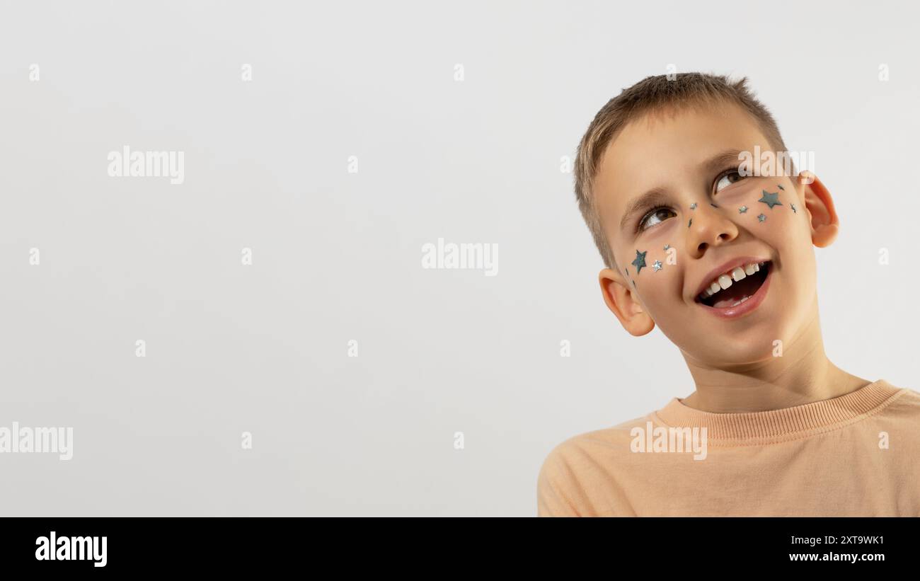 Dreaming smiling boy with stars on face and design template Stock Photo ...