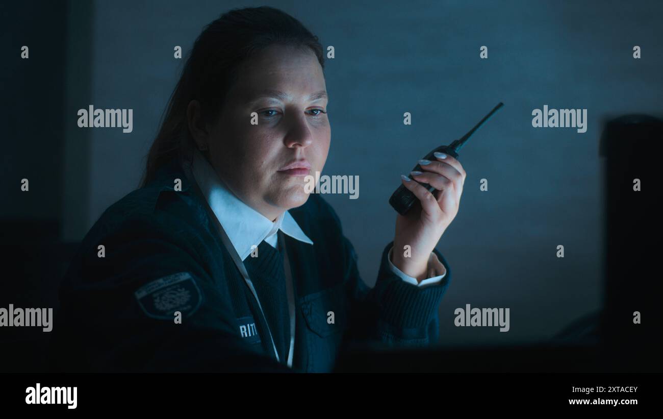 Female security officer or dispatch in uniform uses walkie talkie ...