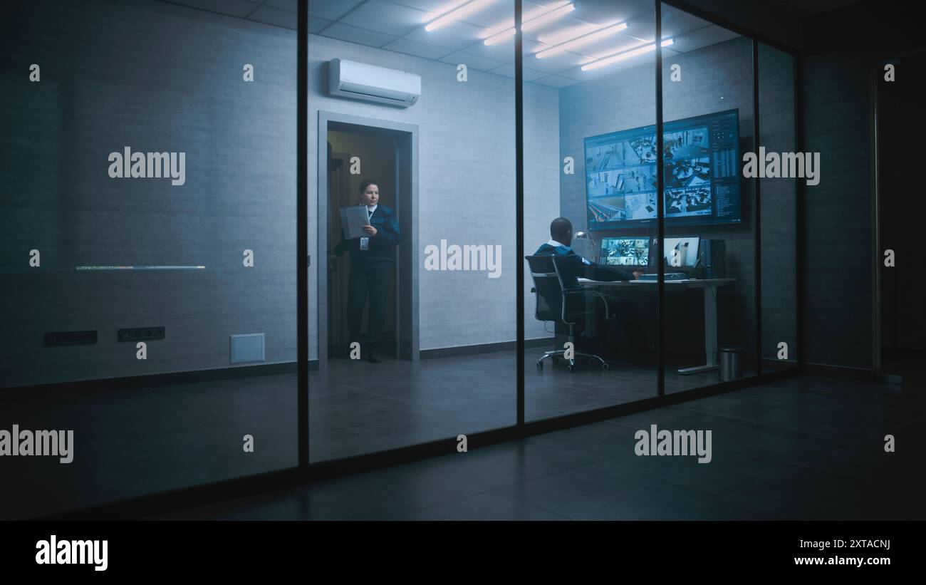 African American CCTV operator works on computer watching security ...