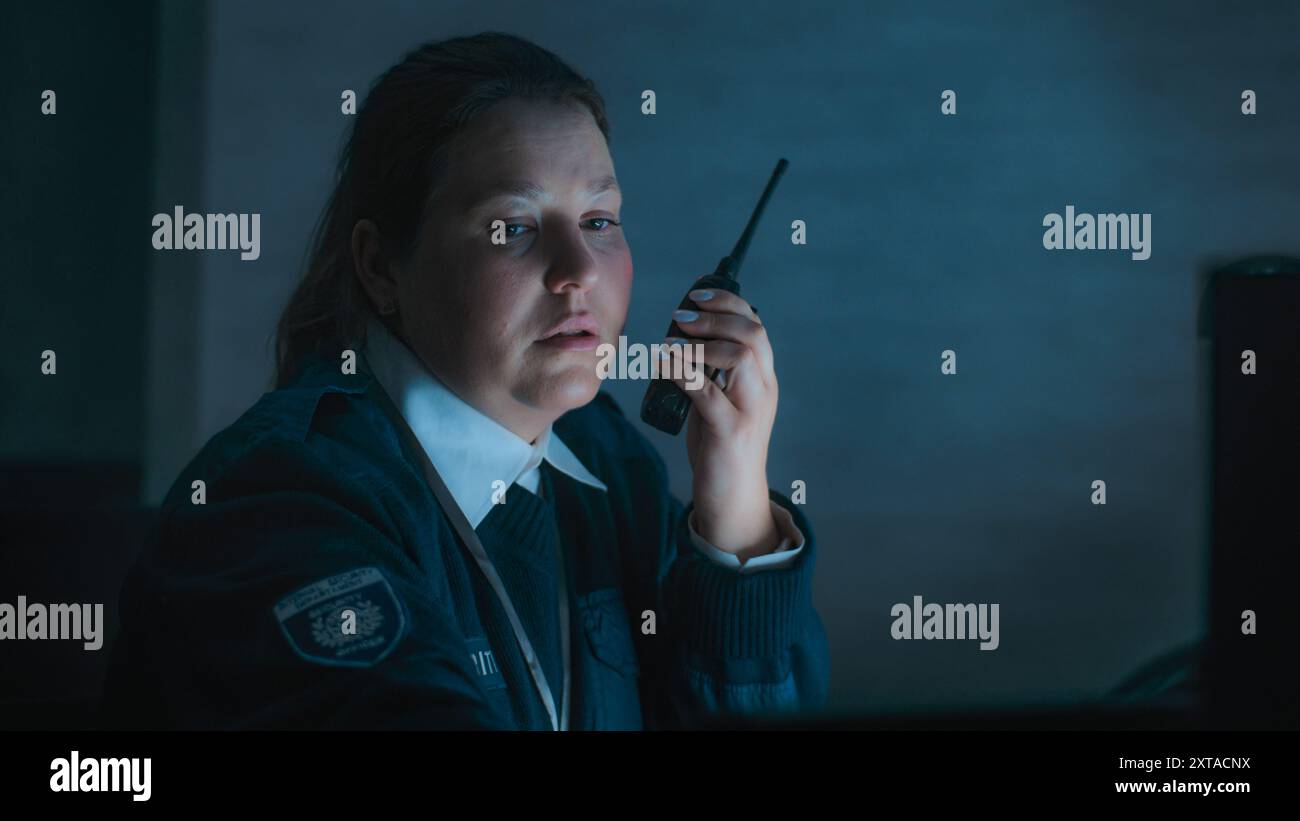 Female security officer or dispatch in uniform uses walkie talkie ...