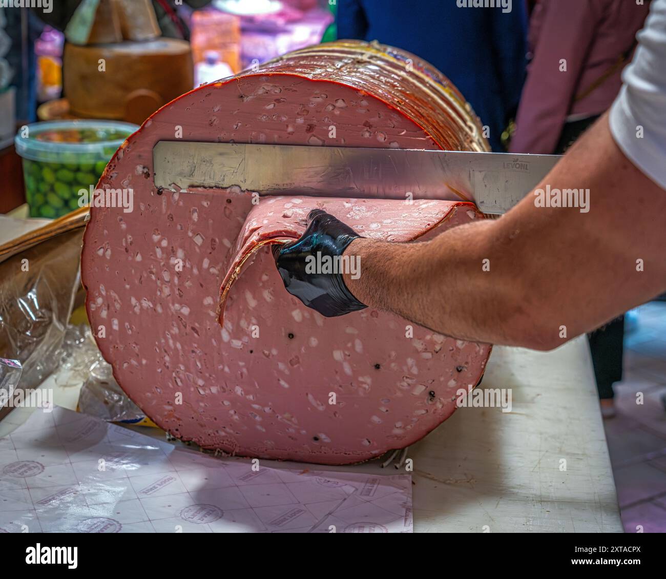 Giant roll of mortadella sliced with a knife during the town's patronal ...