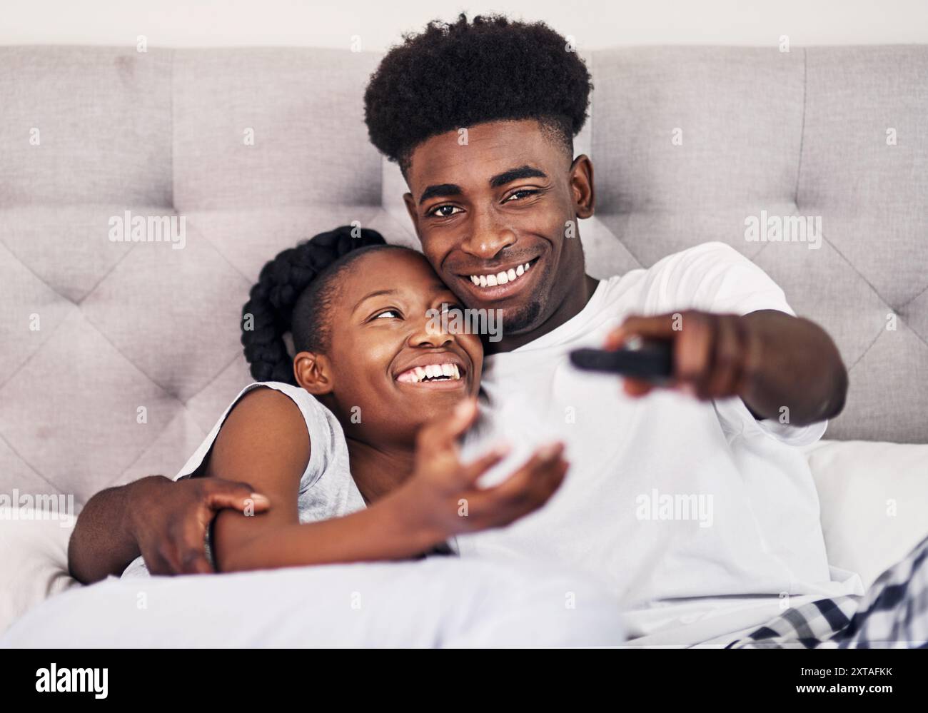 Black couple, people and happy with watching tv in bedroom with ...
