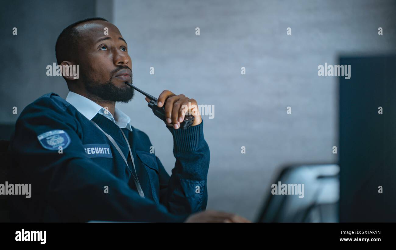 African American security officer or dispatch in uniform uses tablet ...