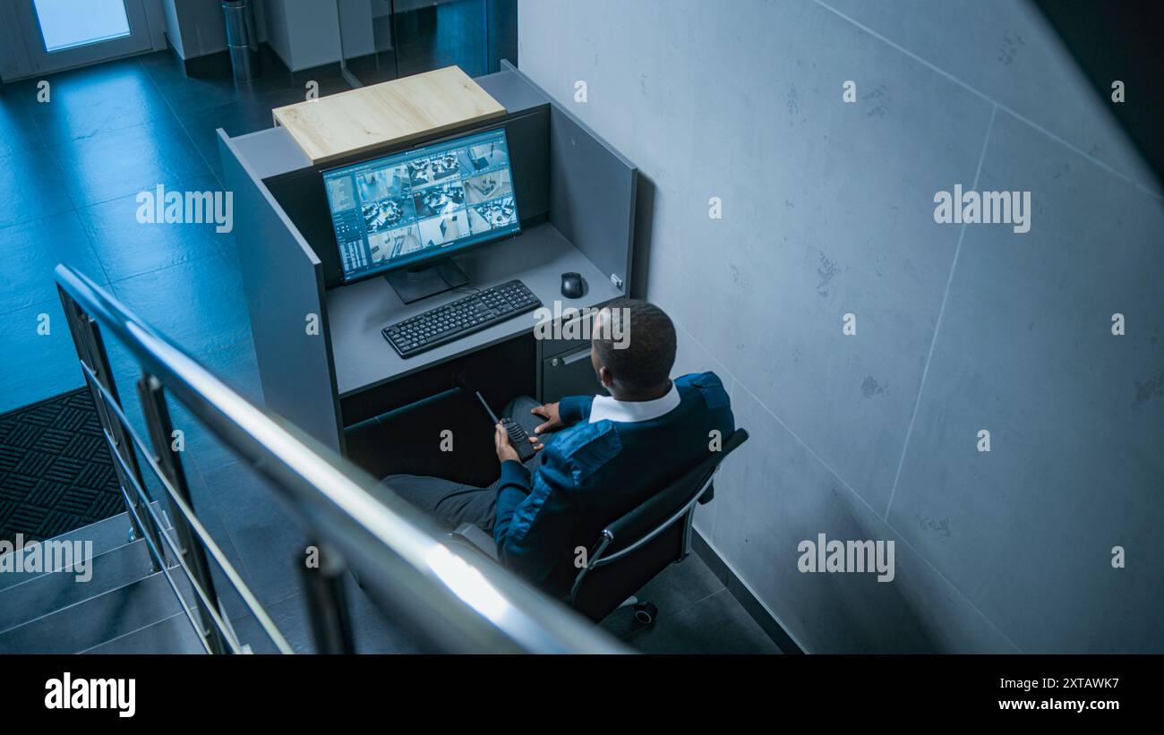 African American male security guard sits at the workplace in the ...