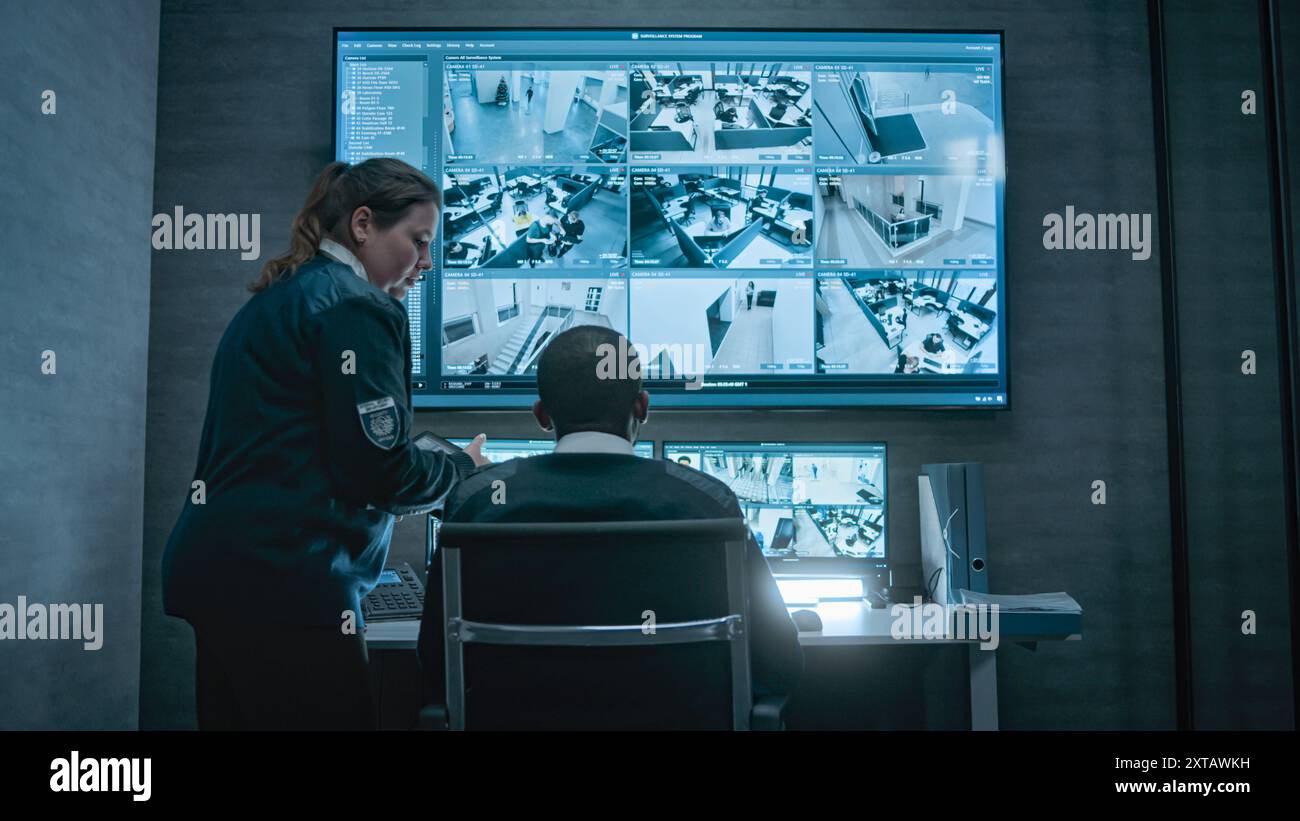 Female security employee talks with African American coworker, uses ...