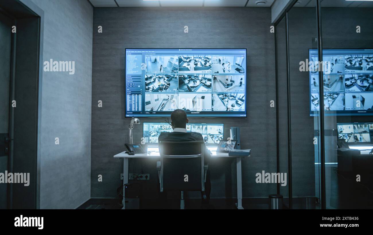 African American CCTV operator works with security cameras on computer ...