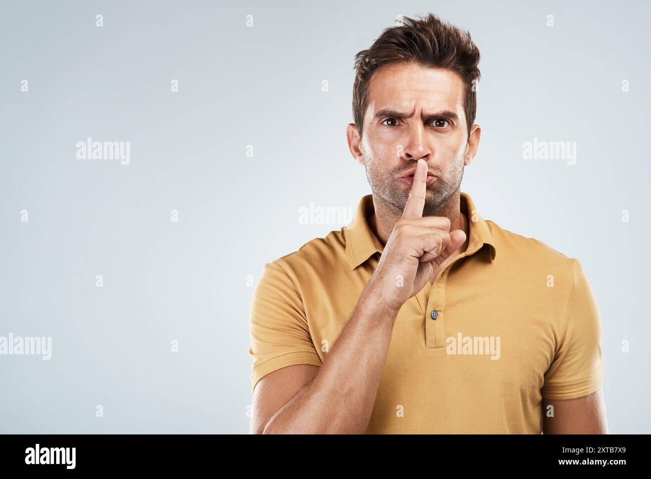 Man, portrait and finger for mystery warning in studio, confidential ...