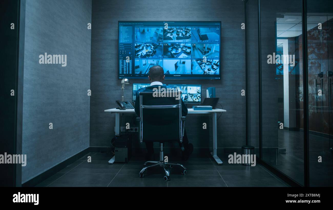 African American male CCTV operator controls office surveillance ...