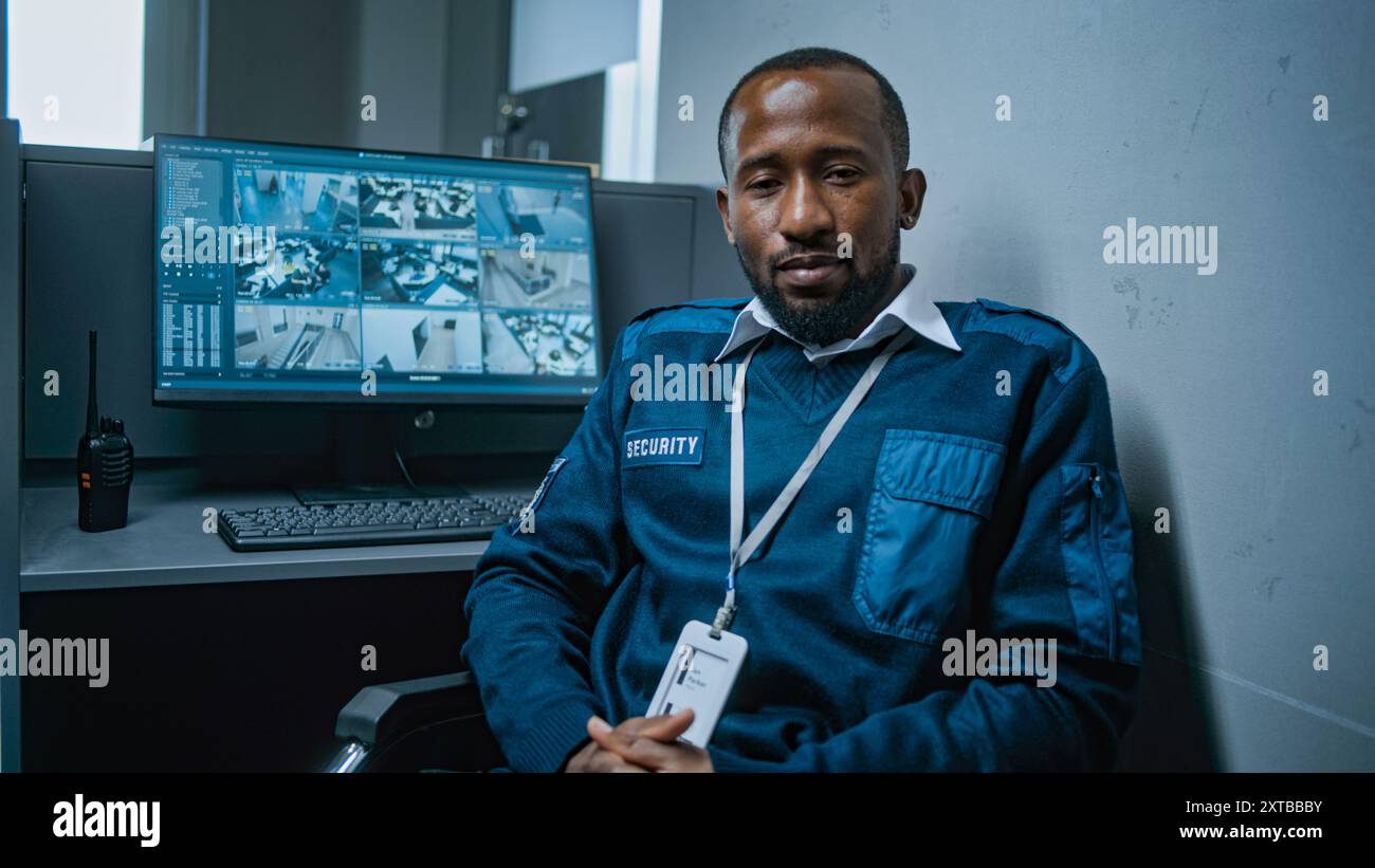 African American male security guard sits at the workplace in the ...
