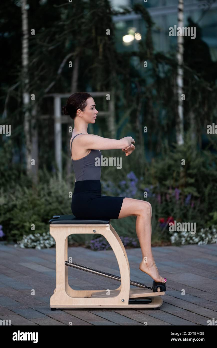 Pilates reformer chair woman fitness yoga gym exercise Stock Photo - Alamy