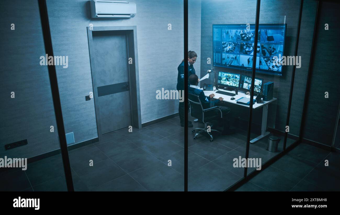 African American CCTV operator works on computer watching security ...