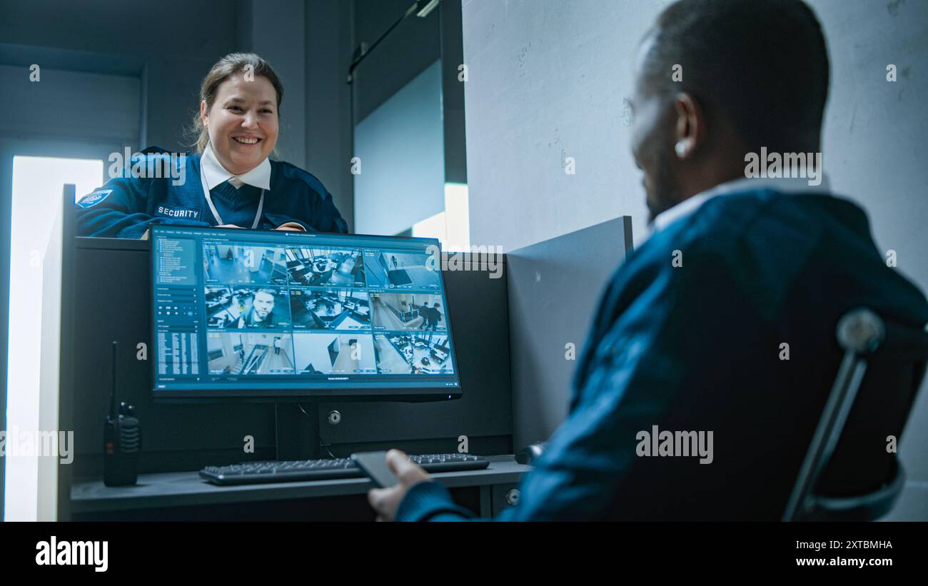 African American male security worker sits at workplace with computer ...