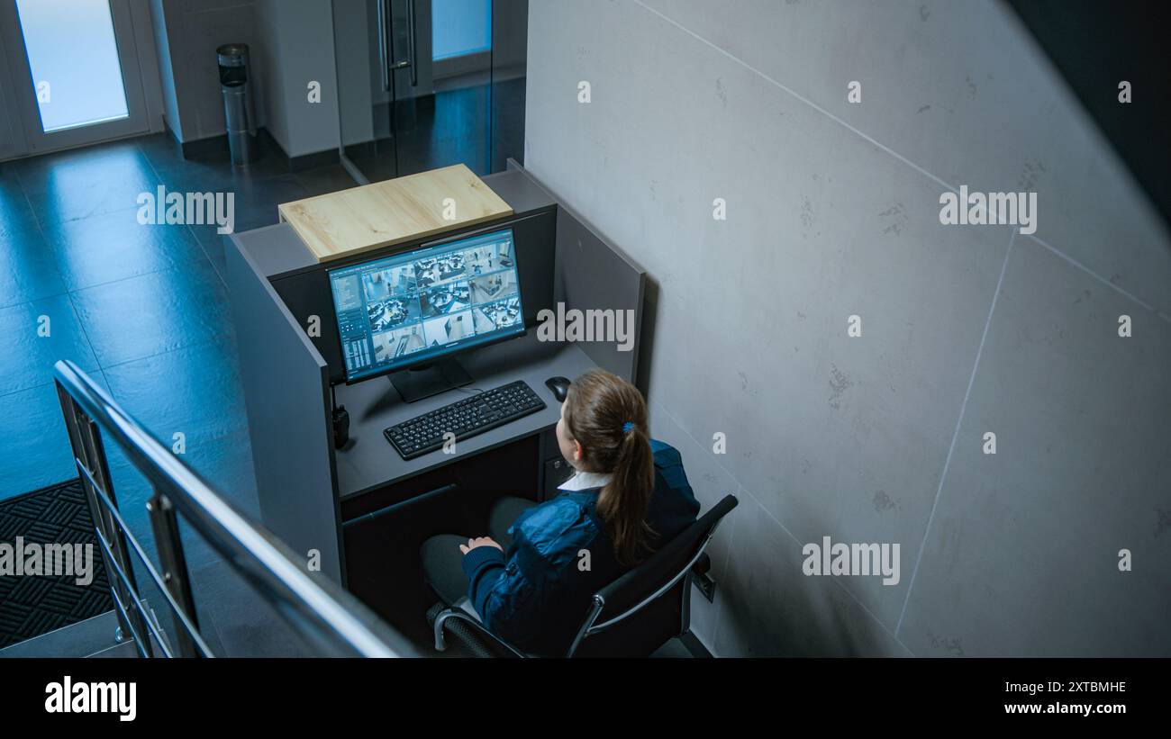 Caucasian female security guard sits at the workplace in the office ...