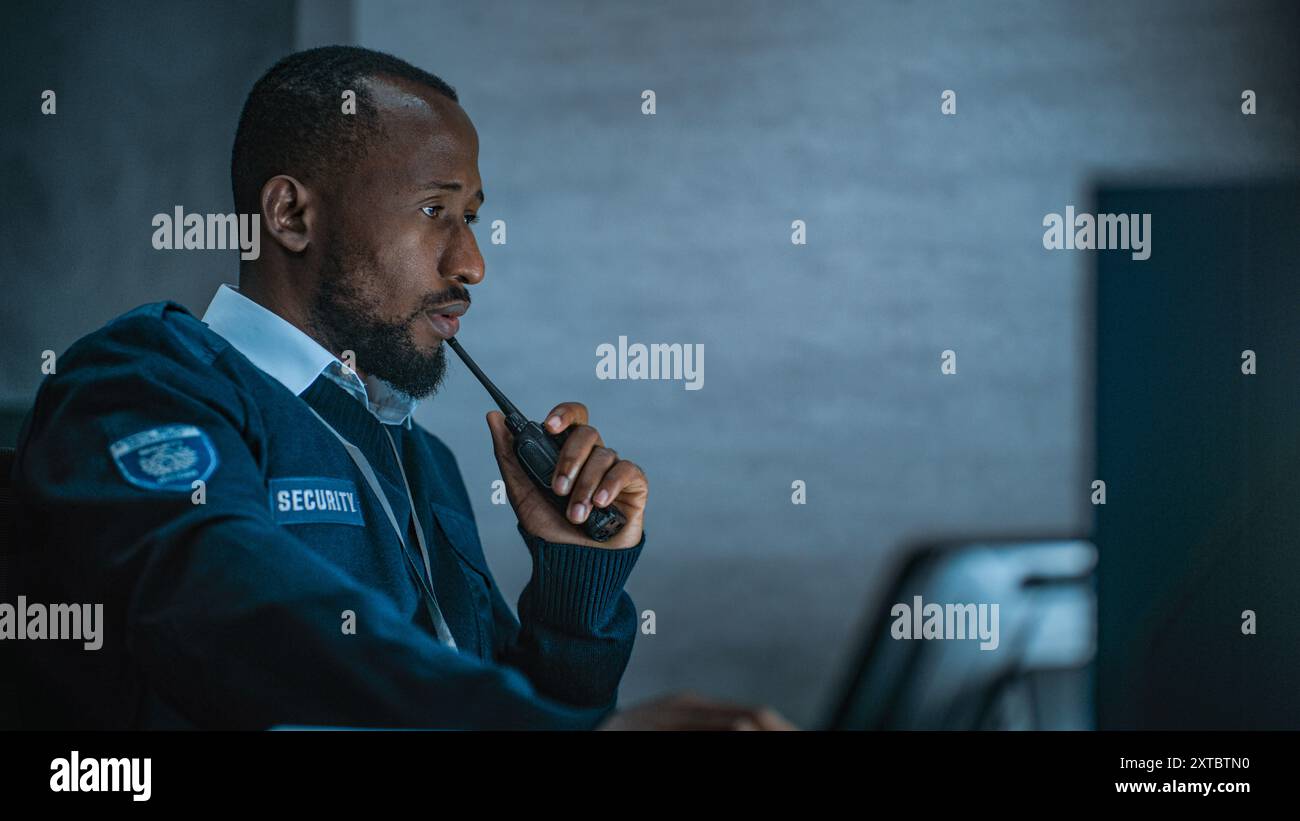 African American security officer or dispatch in uniform uses tablet ...