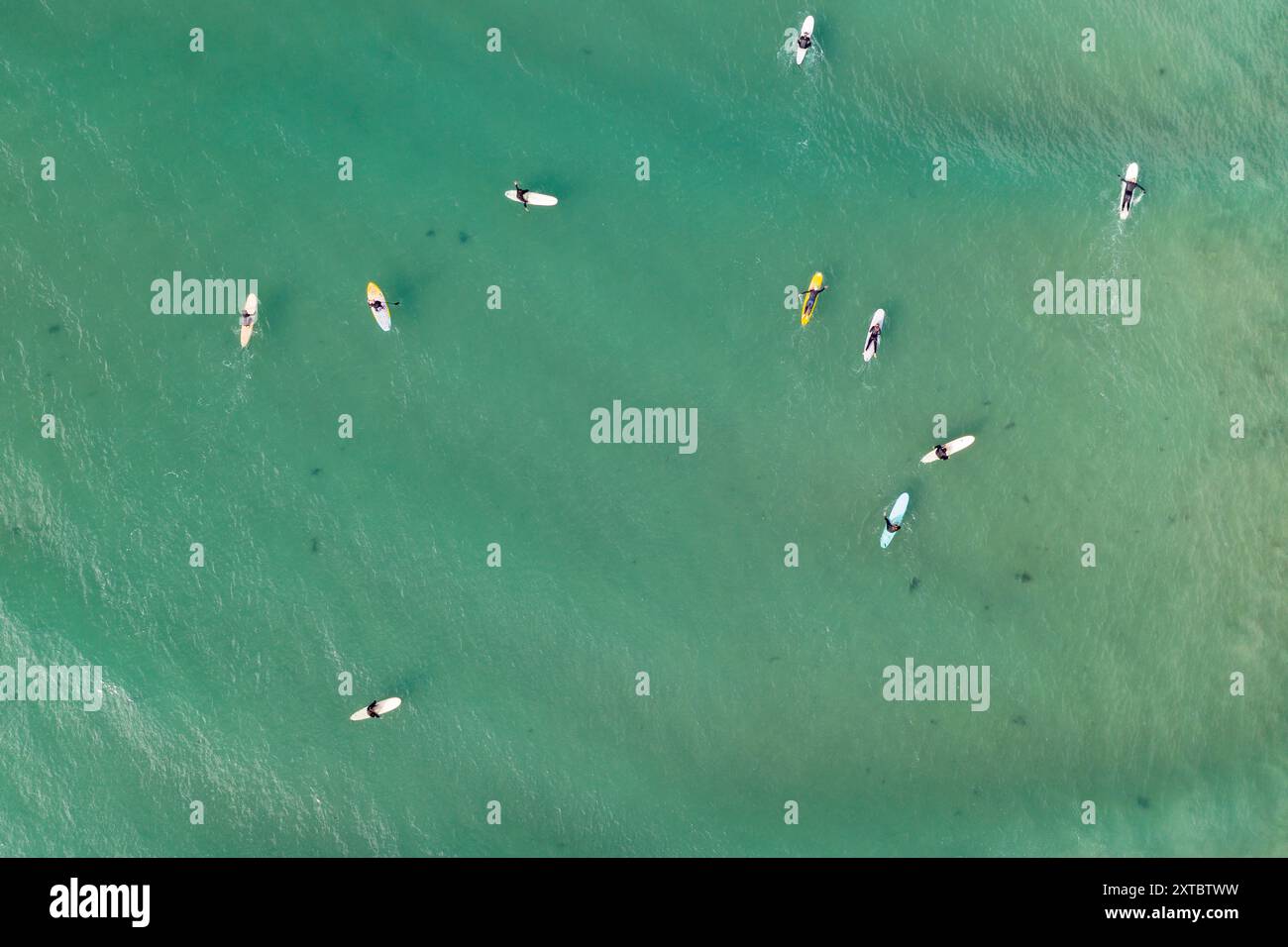 Aerial view of surfers sitting in the sea waiting ona wave at Point ...
