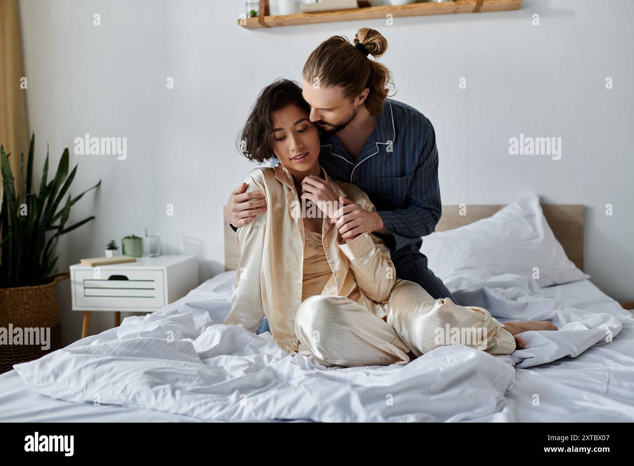 A loving couple cuddles on a bed, enjoying a relaxing moment together ...
