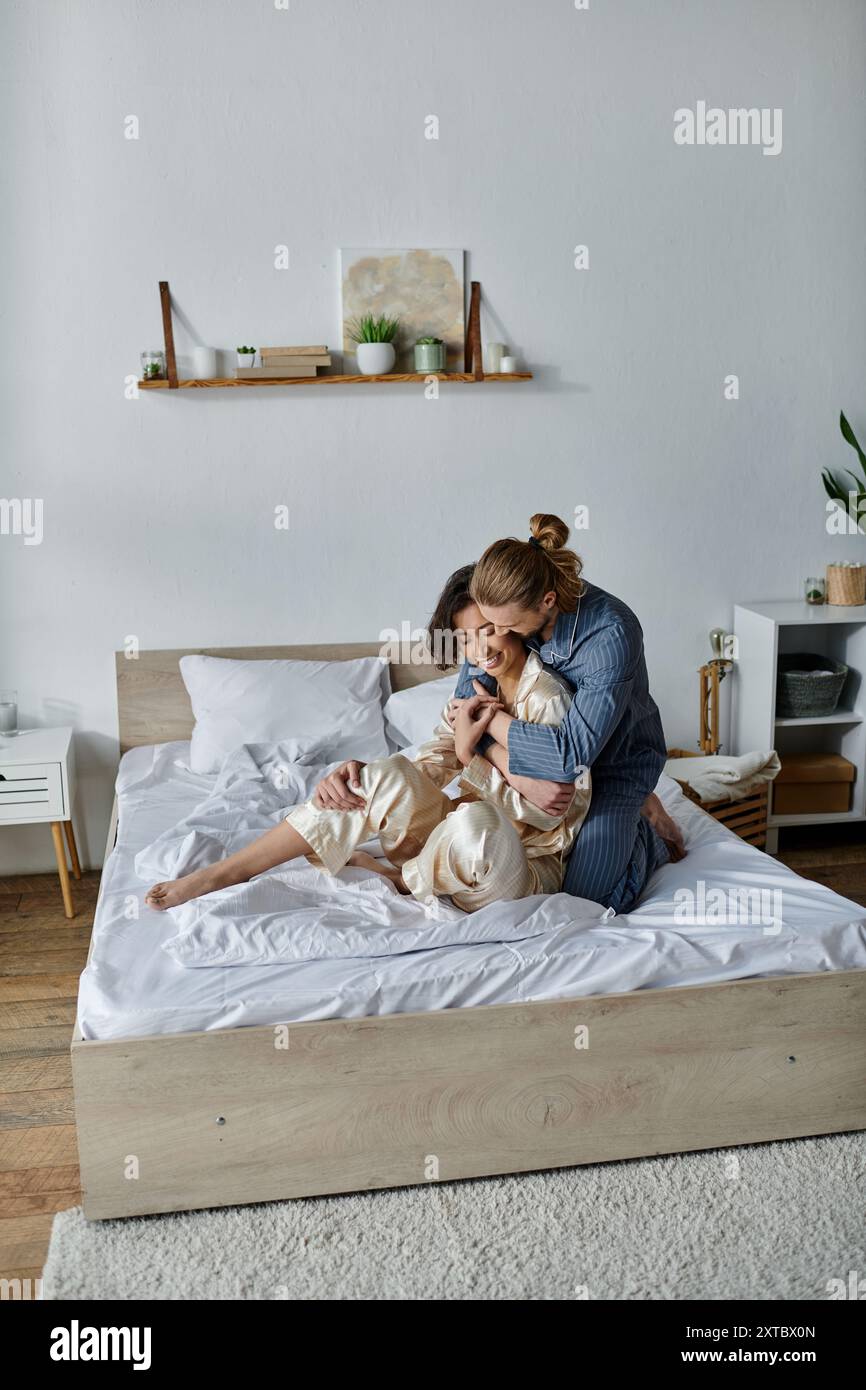 A loving couple cuddles and embraces on a bed, enjoying a moment of ...