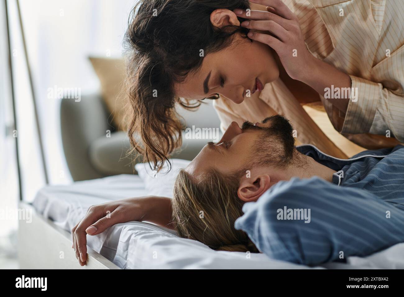 A loving couple share a tender moment in bed, enjoying each others company Stock Photo - Alamy