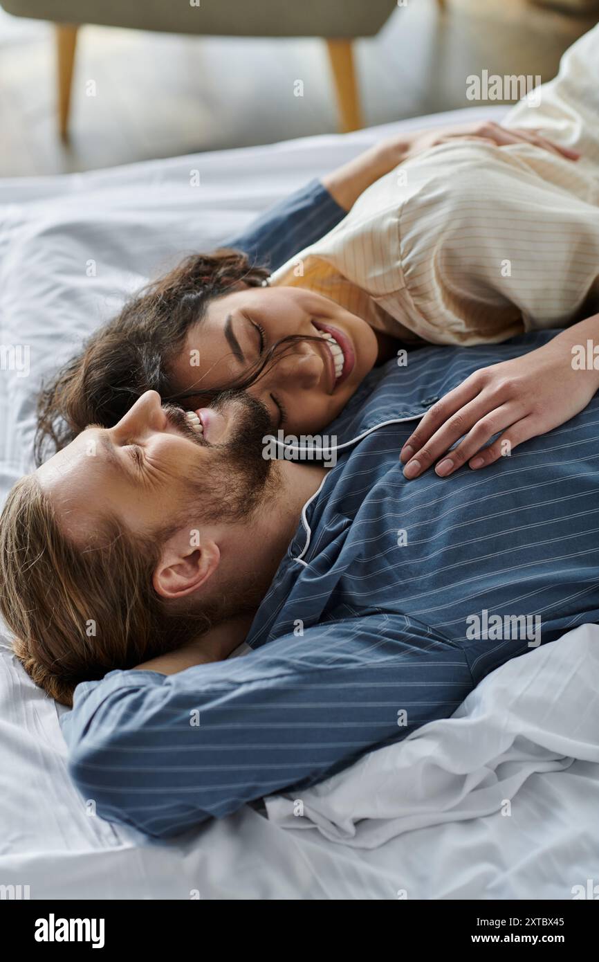 A loving couple cuddles in bed, enjoying a relaxing morning together ...