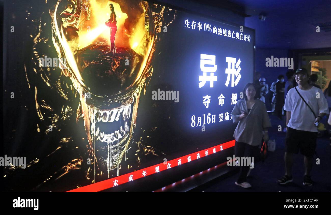SHANGHAI, CHINA - AUGUST 13, 2024 - Fans walk past a promotional poster ...
