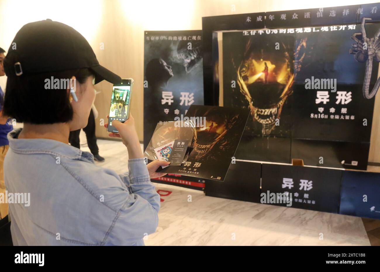 SHANGHAI, CHINA - AUGUST 13, 2024 - A fan takes pictures of a poster ...