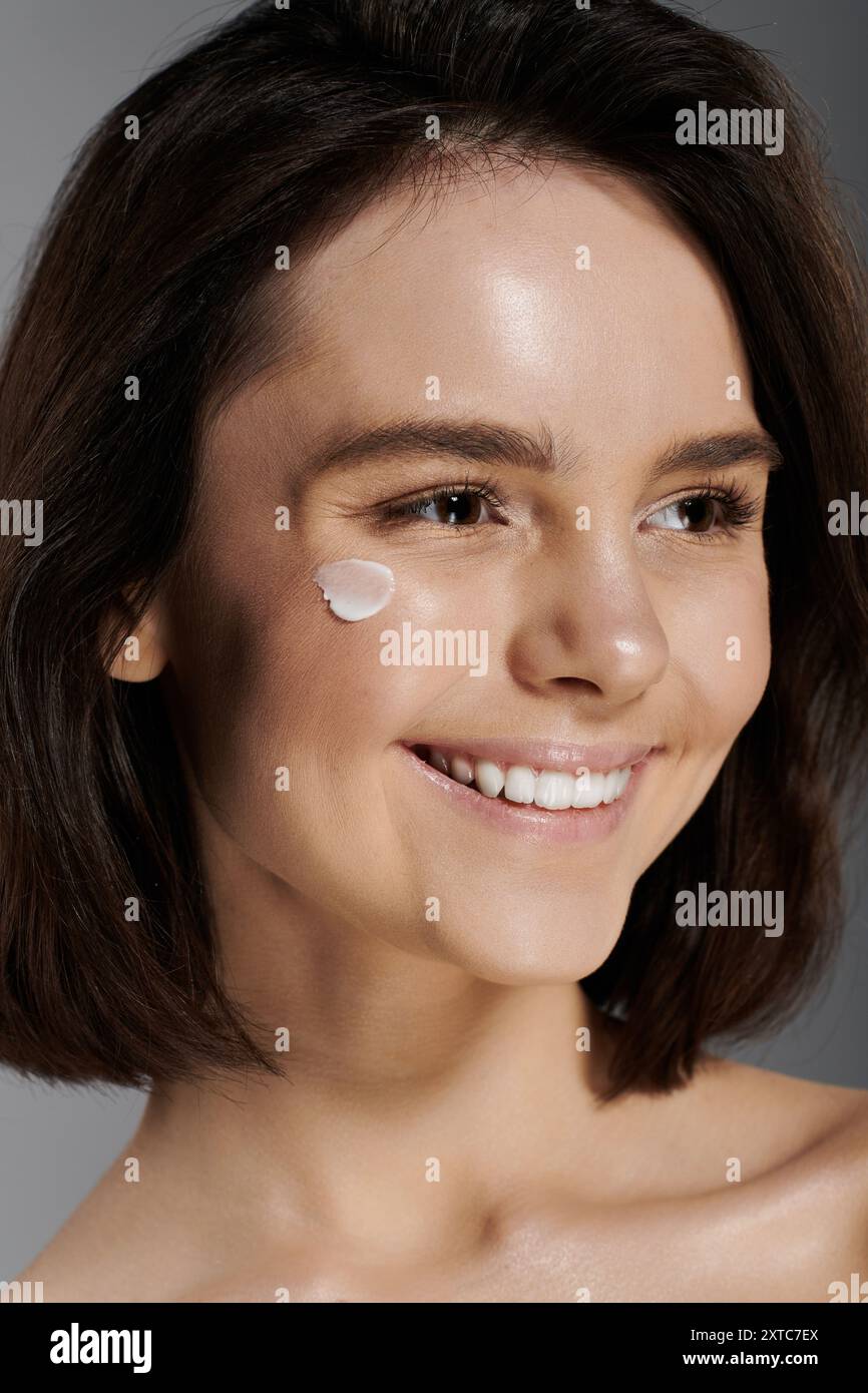 A close-up portrait of a woman with a radiant smile, highlighting her ...