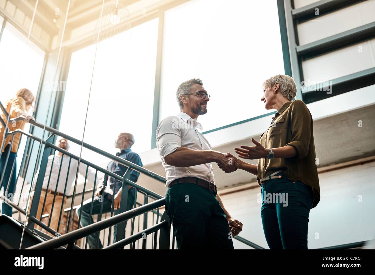 Employees, handshake and office with greeting on stairs for business ...