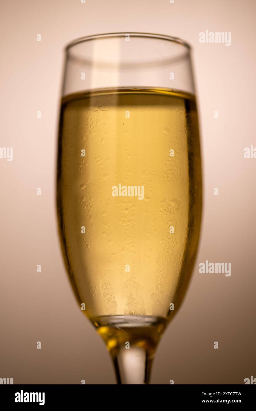 A vertical close-up of a chilled champagne glass, filled with sparkling ...