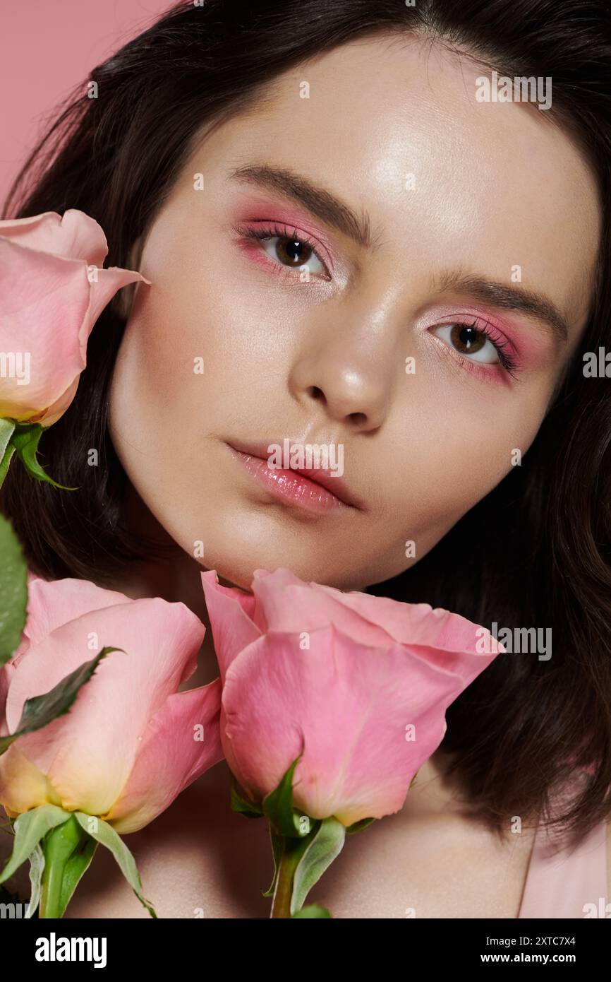 A woman with soft, pink makeup poses against a vivid backdrop of ...
