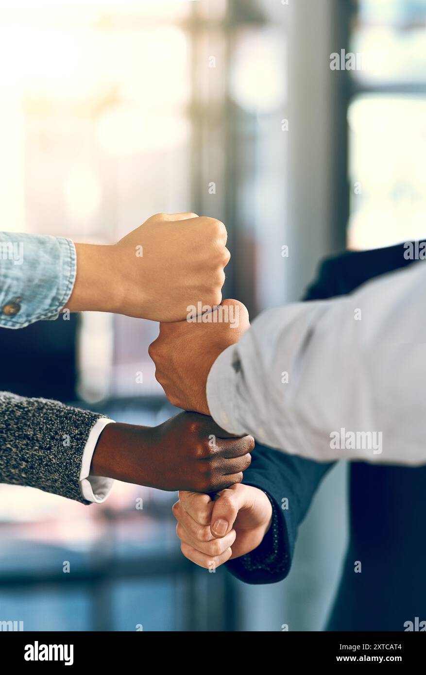 Business people, fist and stack in office for teamwork, inclusion or equality with motivation ...