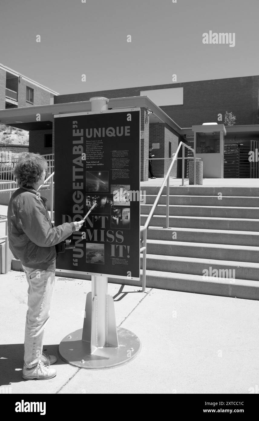 Caucasian woman in her 50s to 60s reading the entrance sign at Meteor ...