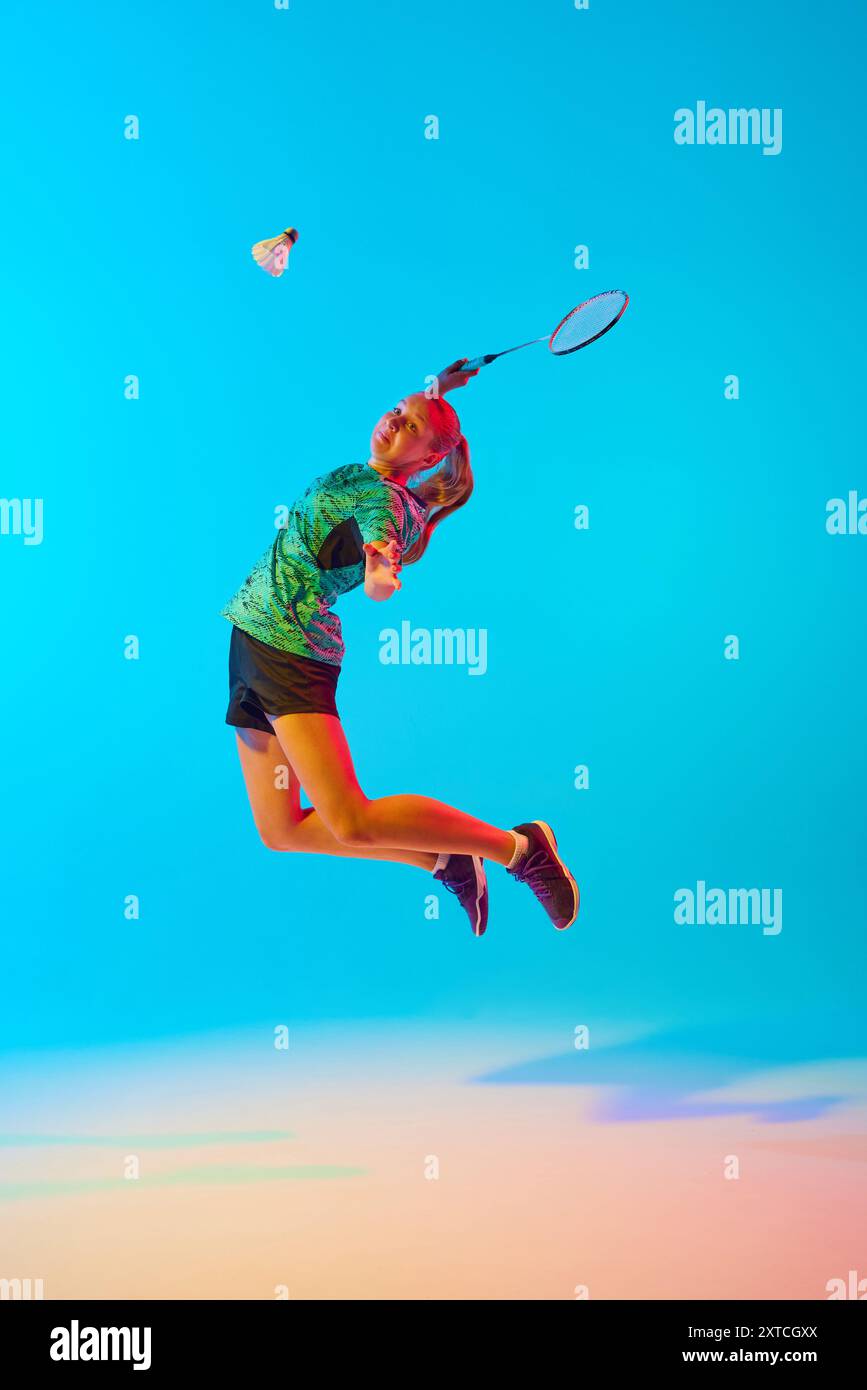 Movement. Young athletic woman playing badminton and jumping, ready to ...