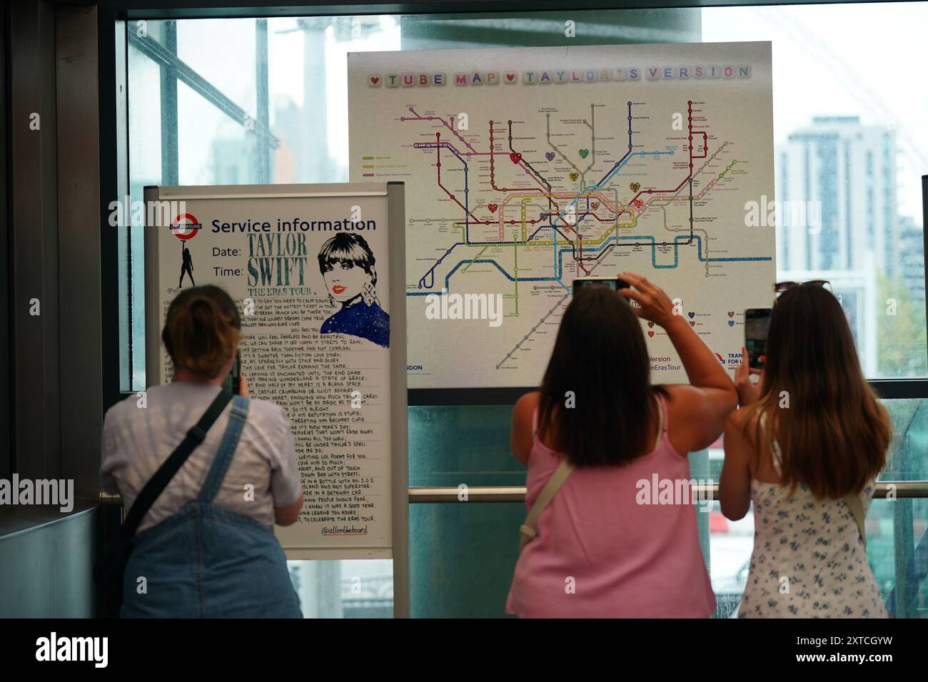 People take photographs of a Taylor Swift service information poster ...