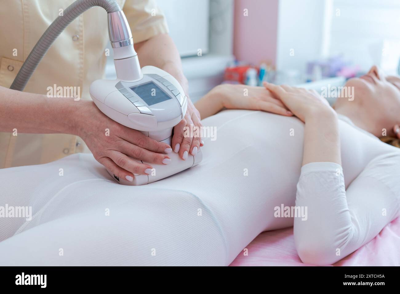 A woman is getting a body contouring treatment. The woman is laying on ...