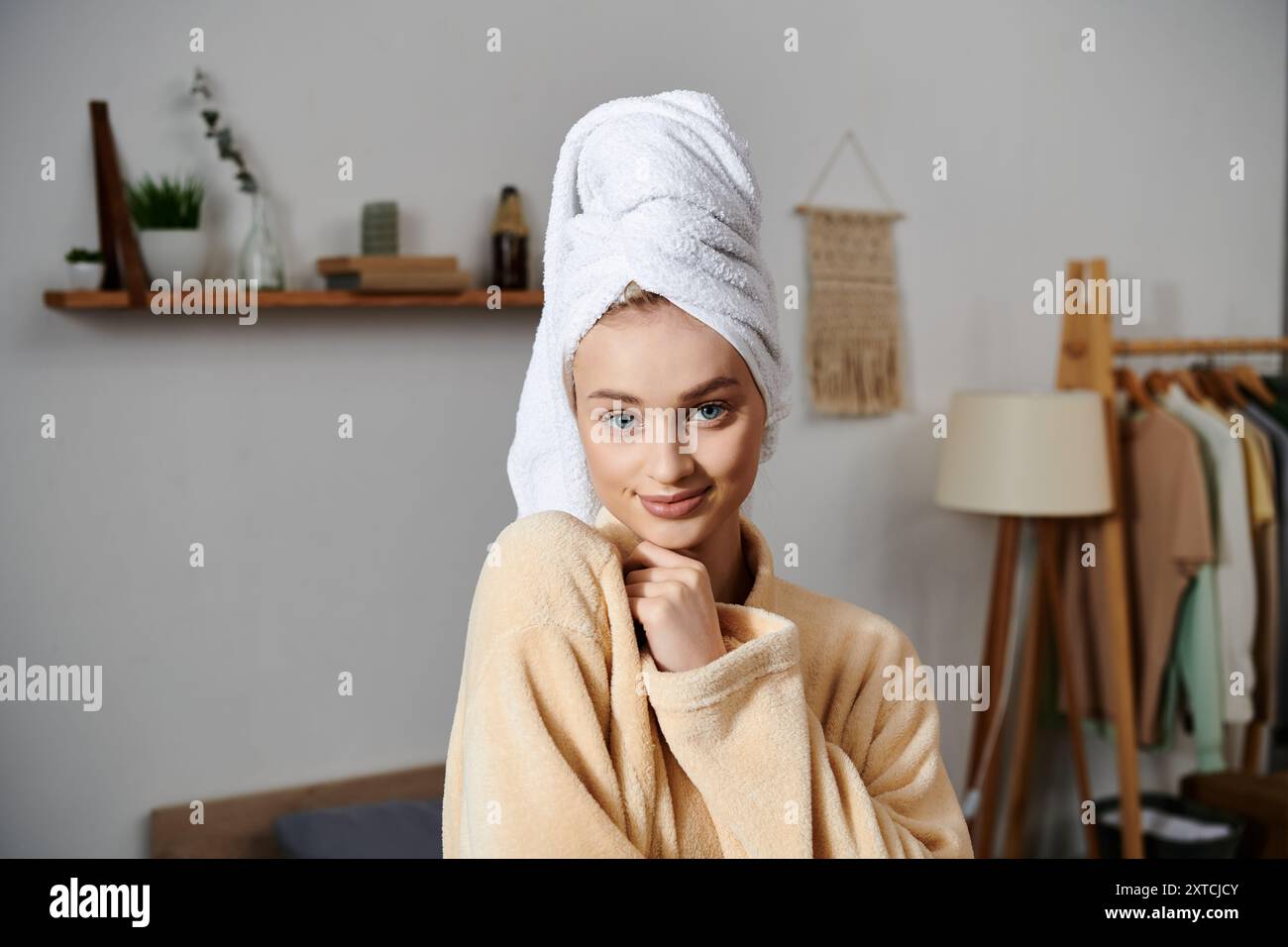 A young woman smiles as she enjoys a moment of relaxation at home ...