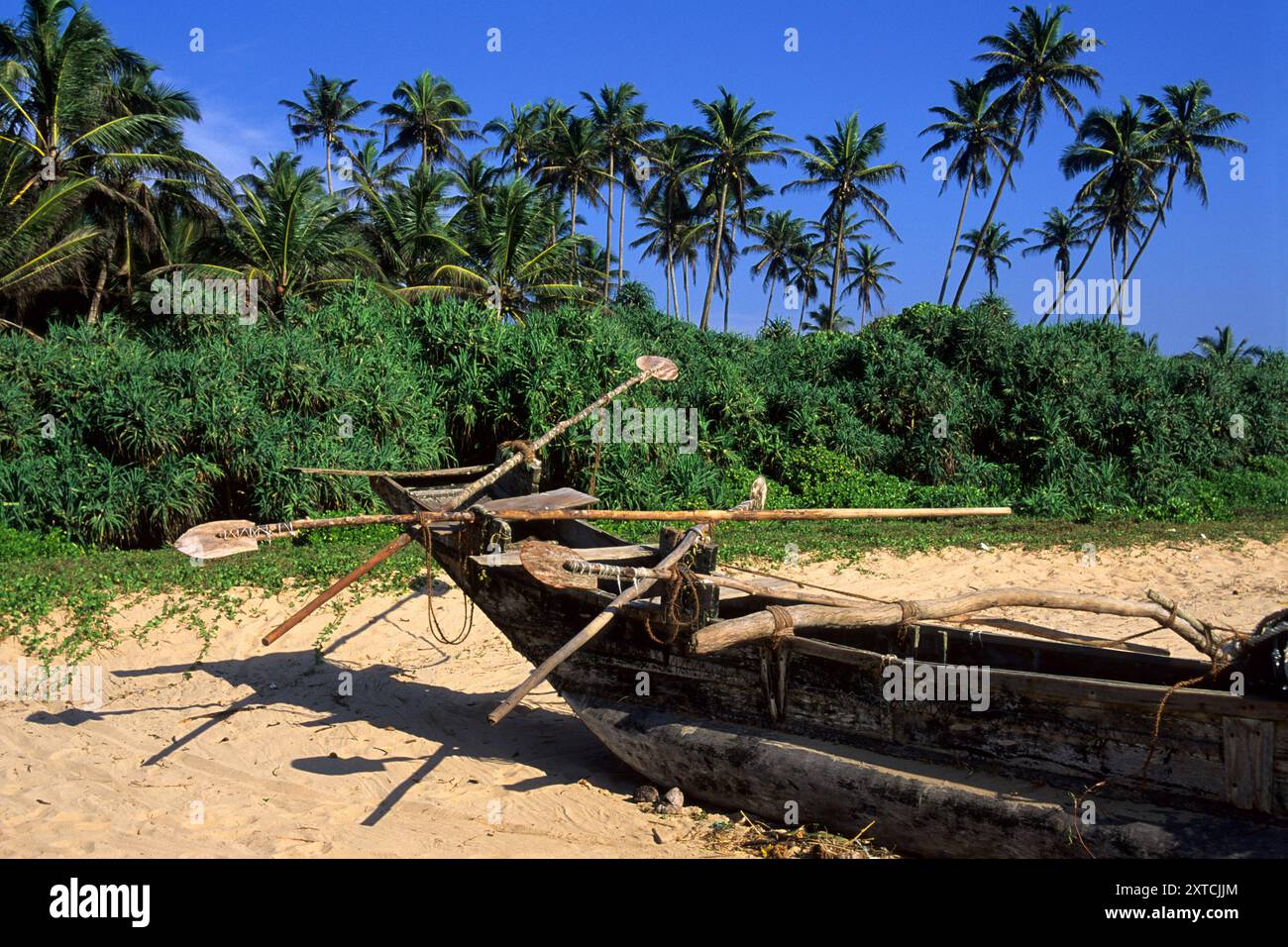 Traditional wooden fishing boat with outrider on Bentota Beach near ...