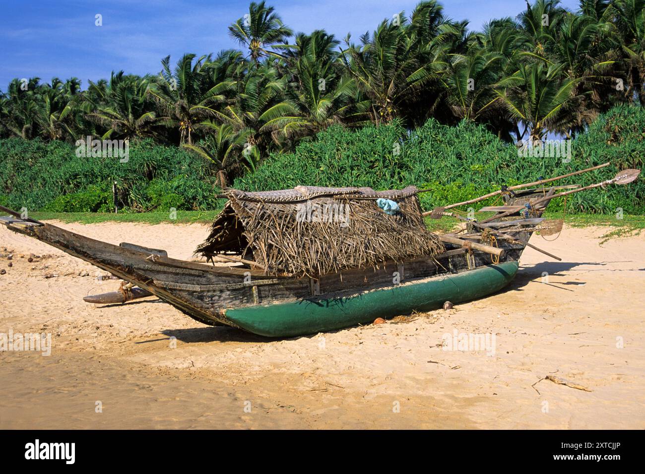 Traditional wooden fishing boat with outrider on Bentota Beach near ...
