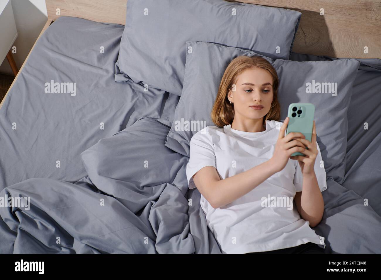 Woman lies in bed browsing hi-res stock photography and images - Alamy