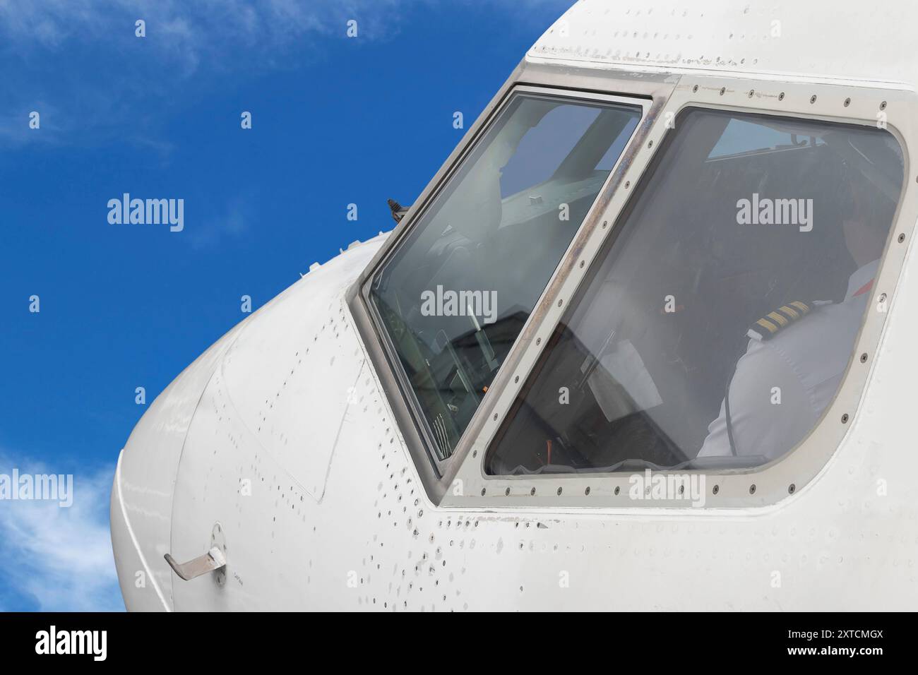 Airplane flying. Commander in the cockpit seen from outside through the ...