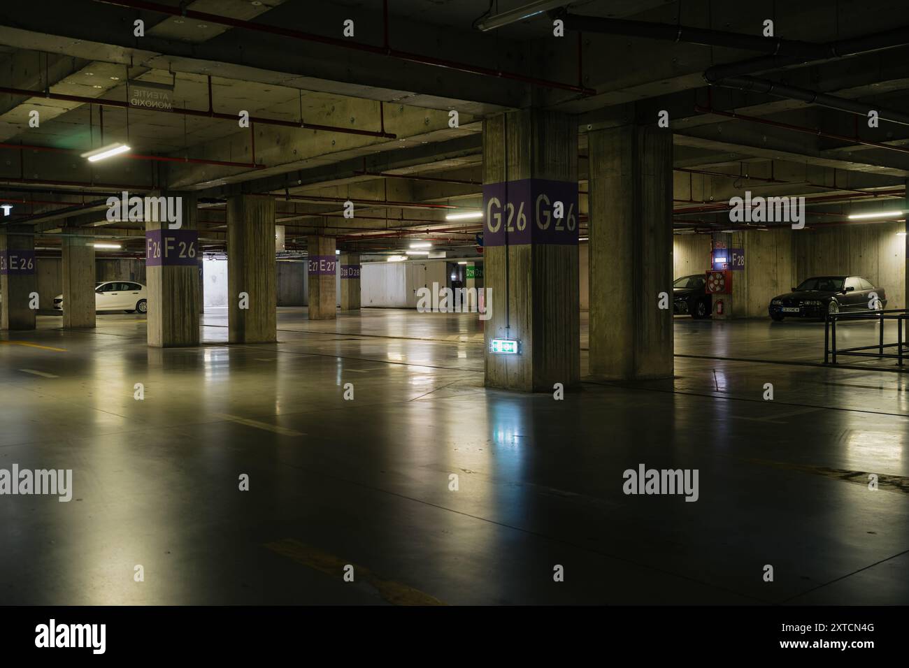 Parking lot with overhead dim light, underground parking garage Stock ...