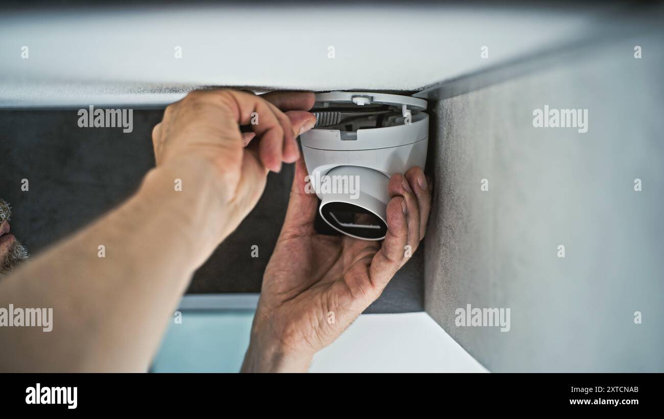 Professional male installer screws cctv hi-res stock photography and ...
