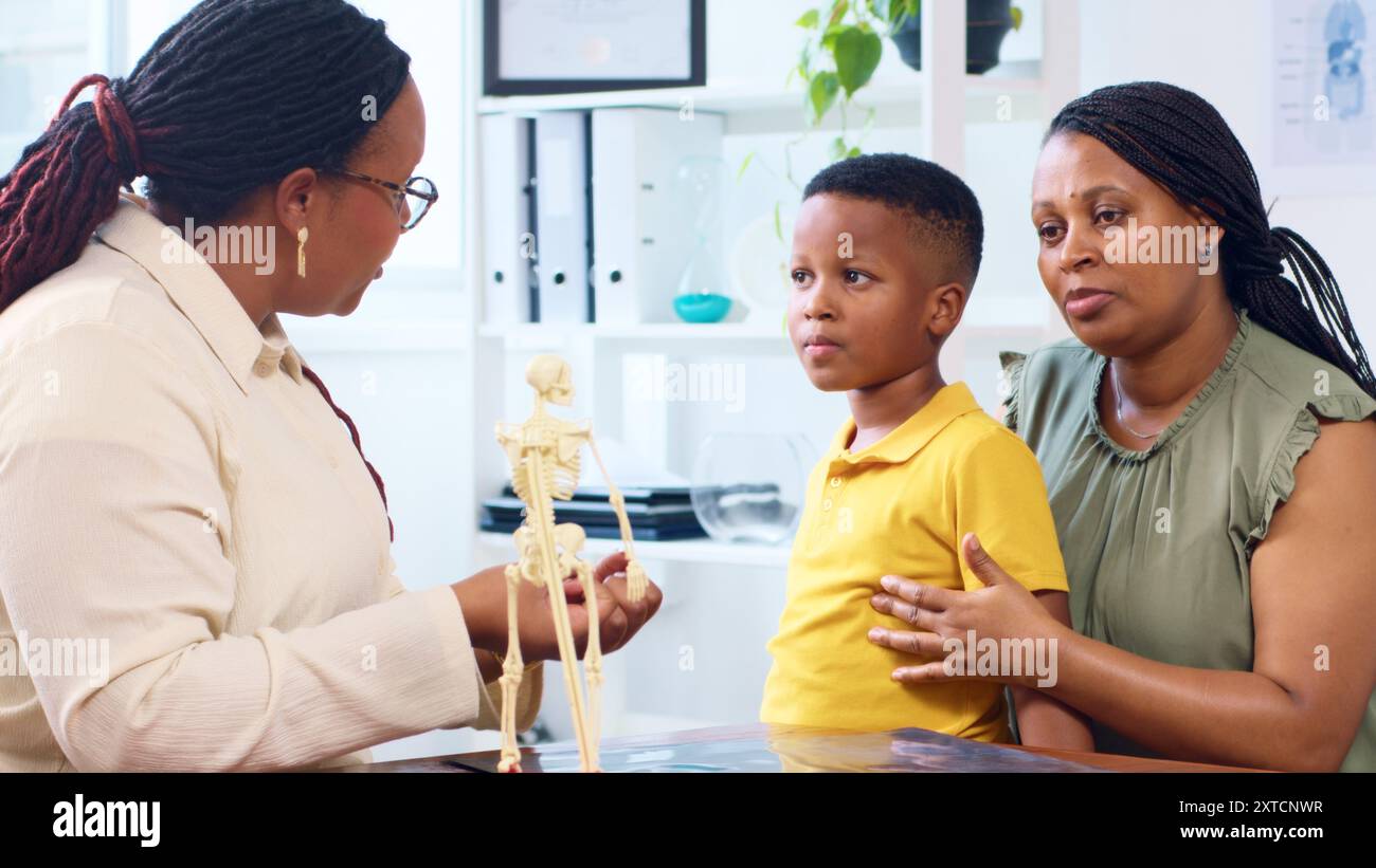 Doctor Consulting with Young Boy and Mother in Medical Office Setting for Child Healthcare ...