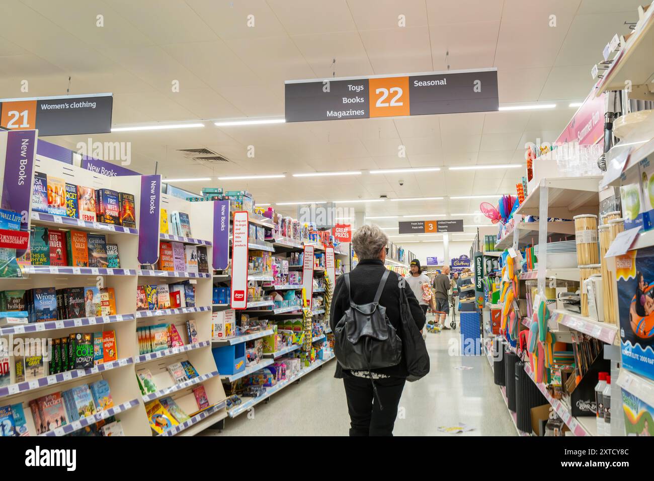 Shoppers customers walking along an aisle inside a Sainsburys store ...
