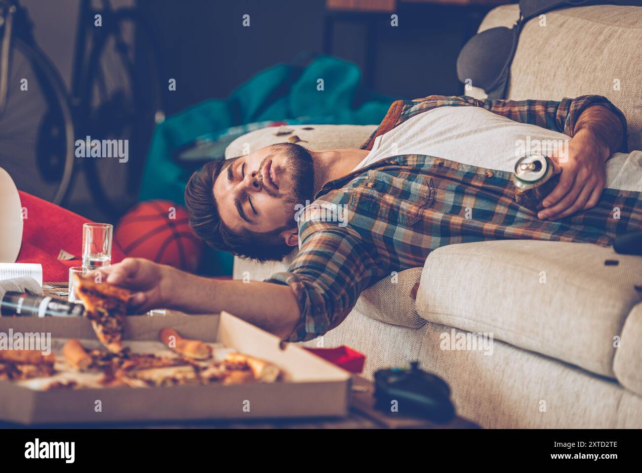 It has been a long night. Young handsome man passed out on sofa with ...