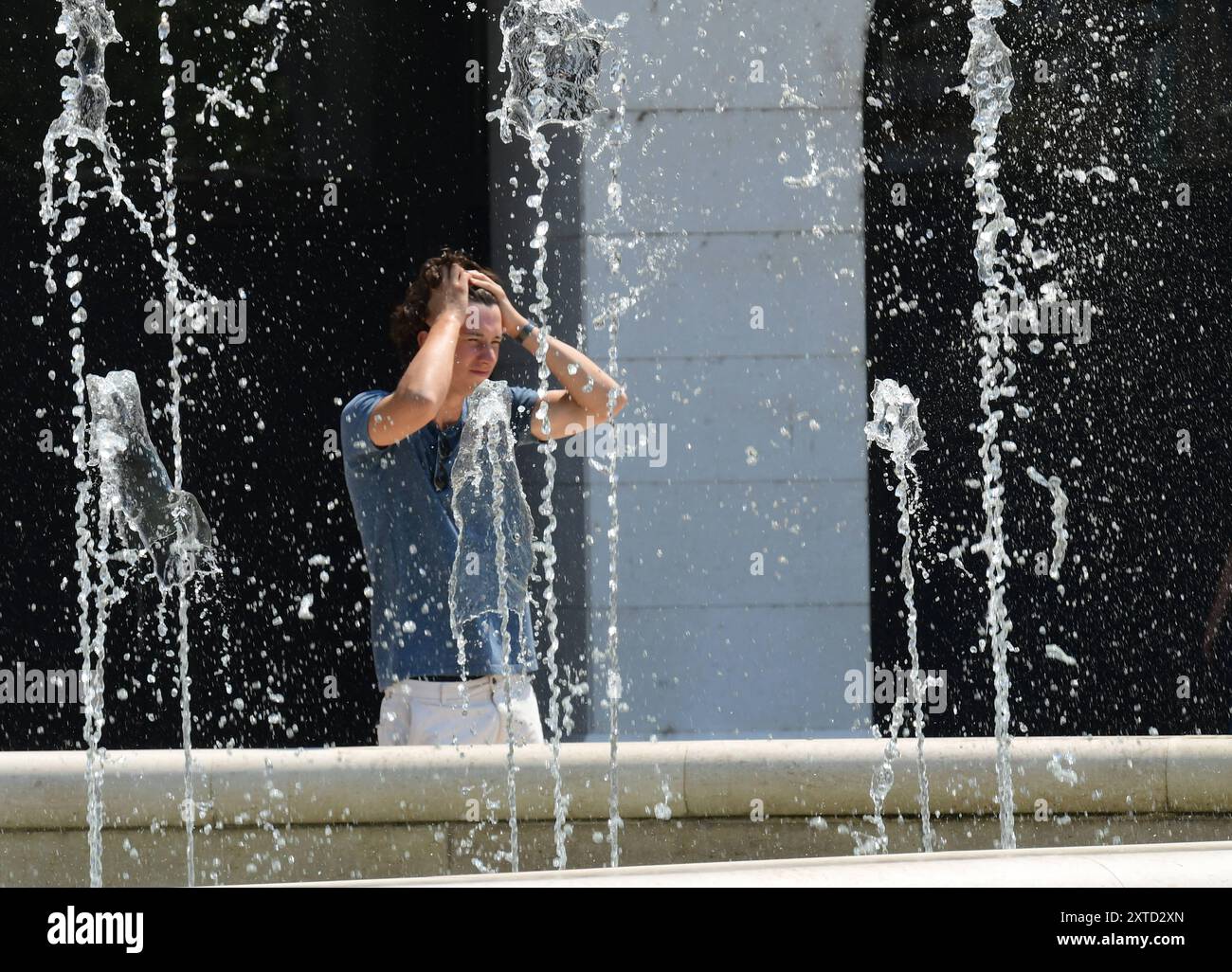 A man refresh himself in a fountain in Skopje, North Macedonia, 14 ...