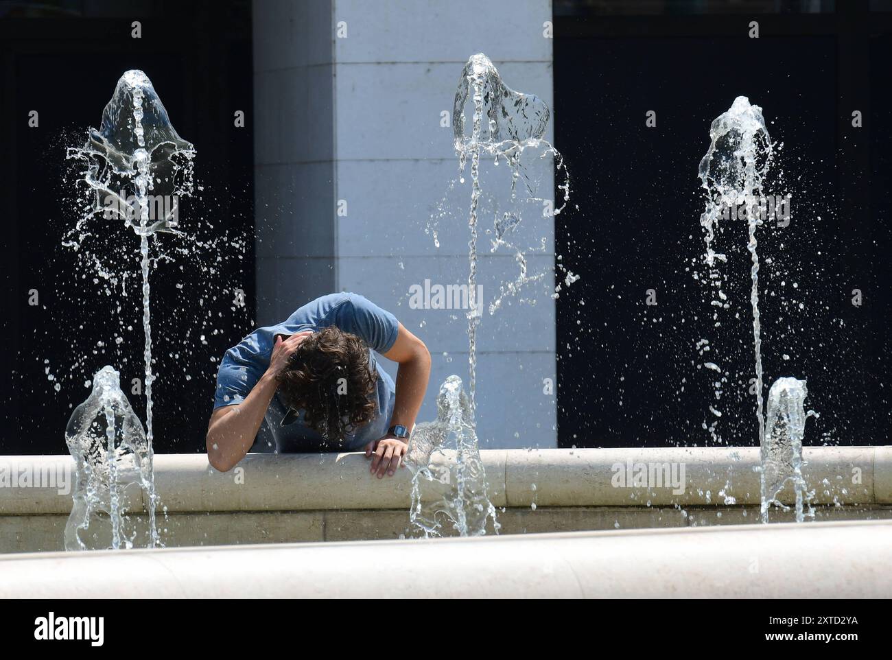 A man refresh himself in a fountain in Skopje, North Macedonia, 14 ...