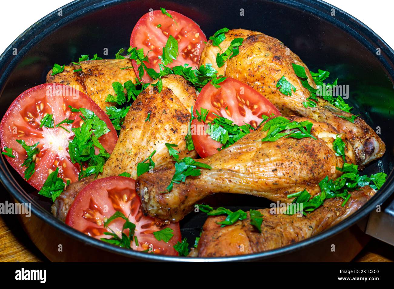 Fried chicken legs with tomatoes and greens Stock Photo - Alamy